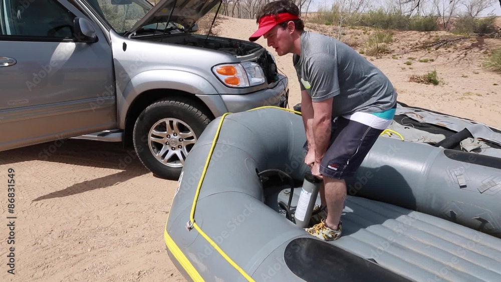 man blowing up raft with a hand pump Stock ビデオ | Adobe Stock