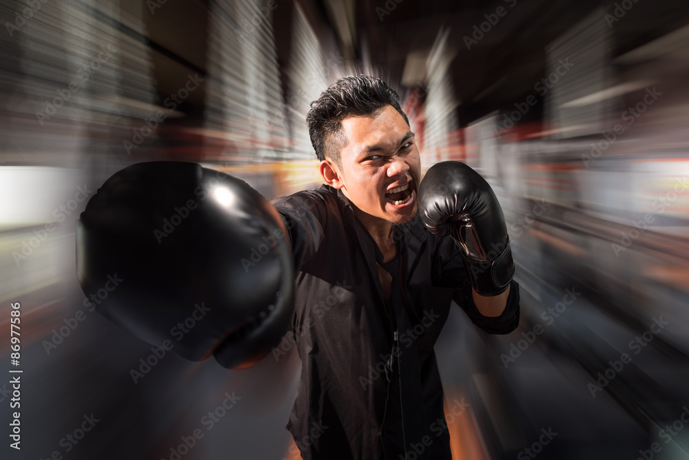 young aggressive businessman training shadow boxing at gym with gloves ...