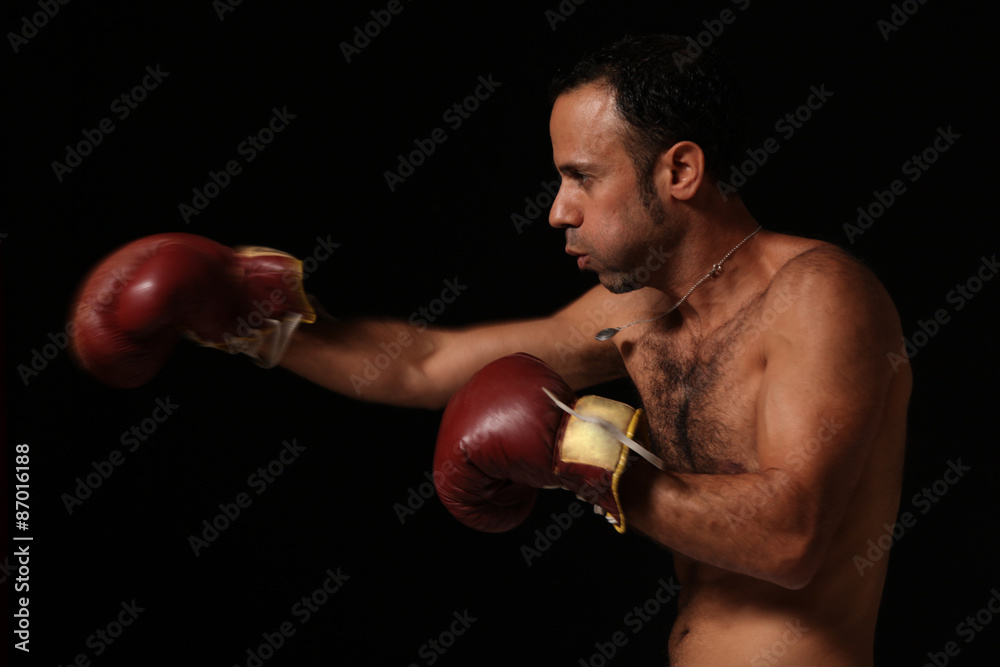 Profile of a boxer with boxing gloves, throwing a punch without shirt ...