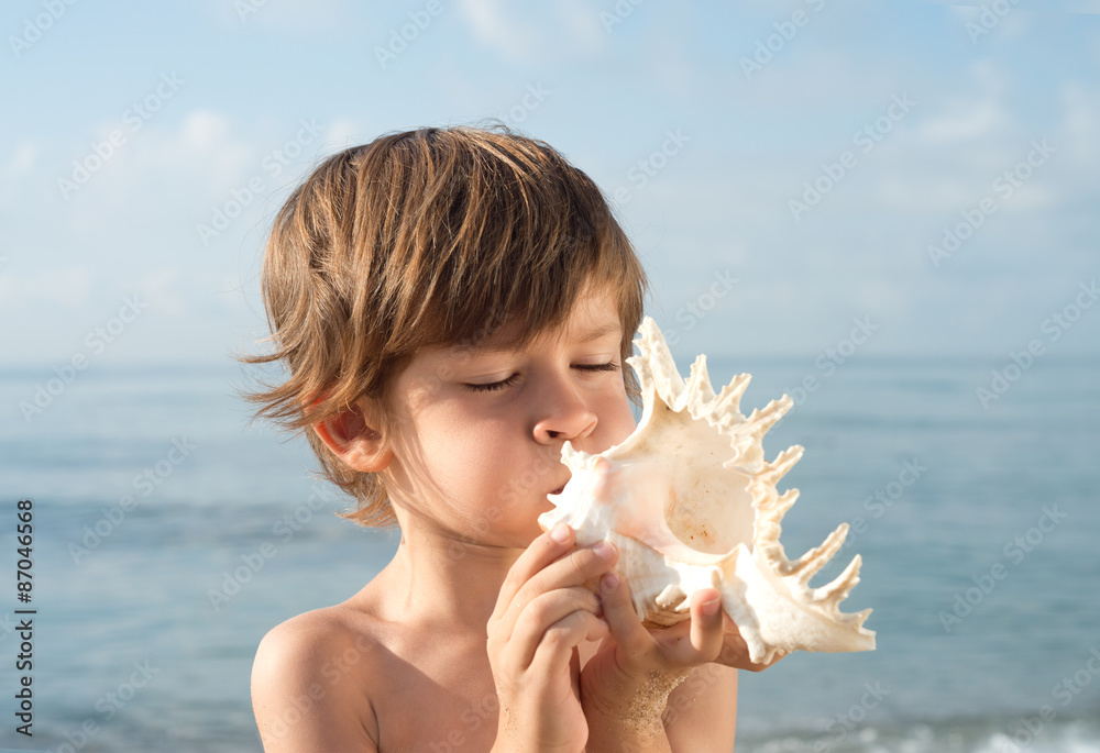 child blowing conch Stock Photo | Adobe Stock