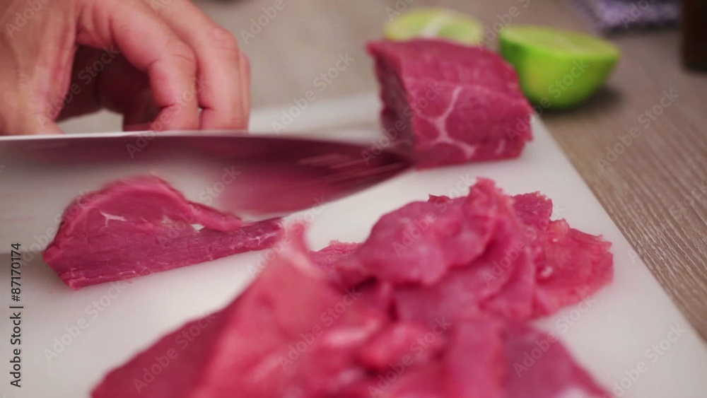 Chef finely slicing beef steak fillet using sharp knife, making beef ...