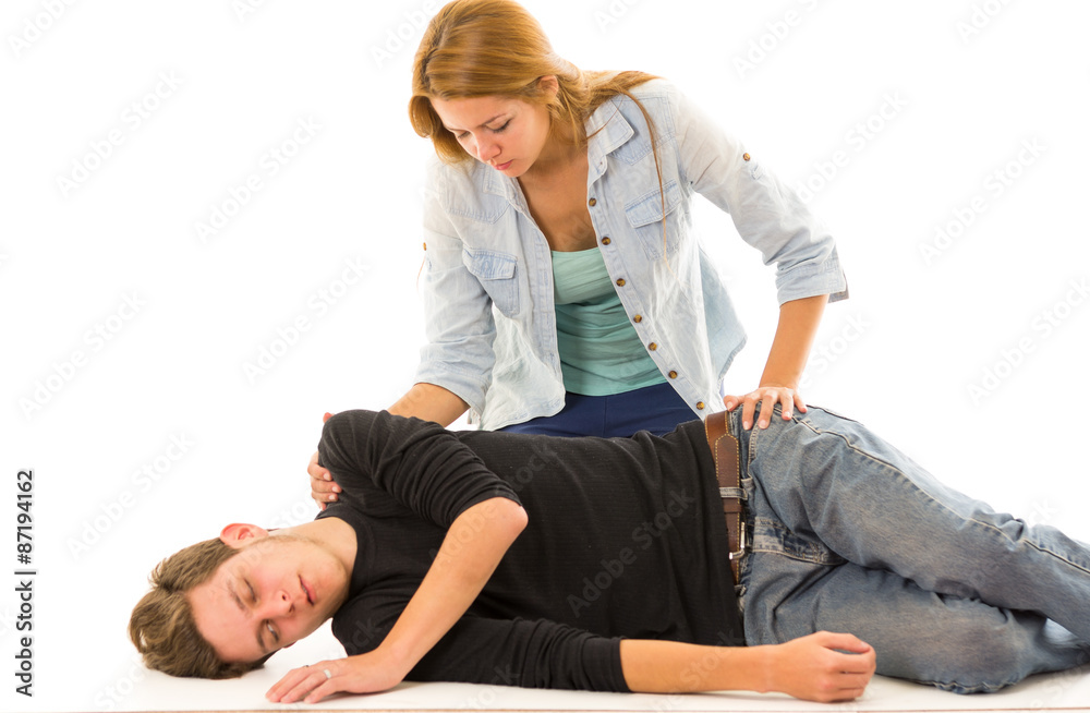 Couple demonstrating first aid techniques with male patient lying in ...