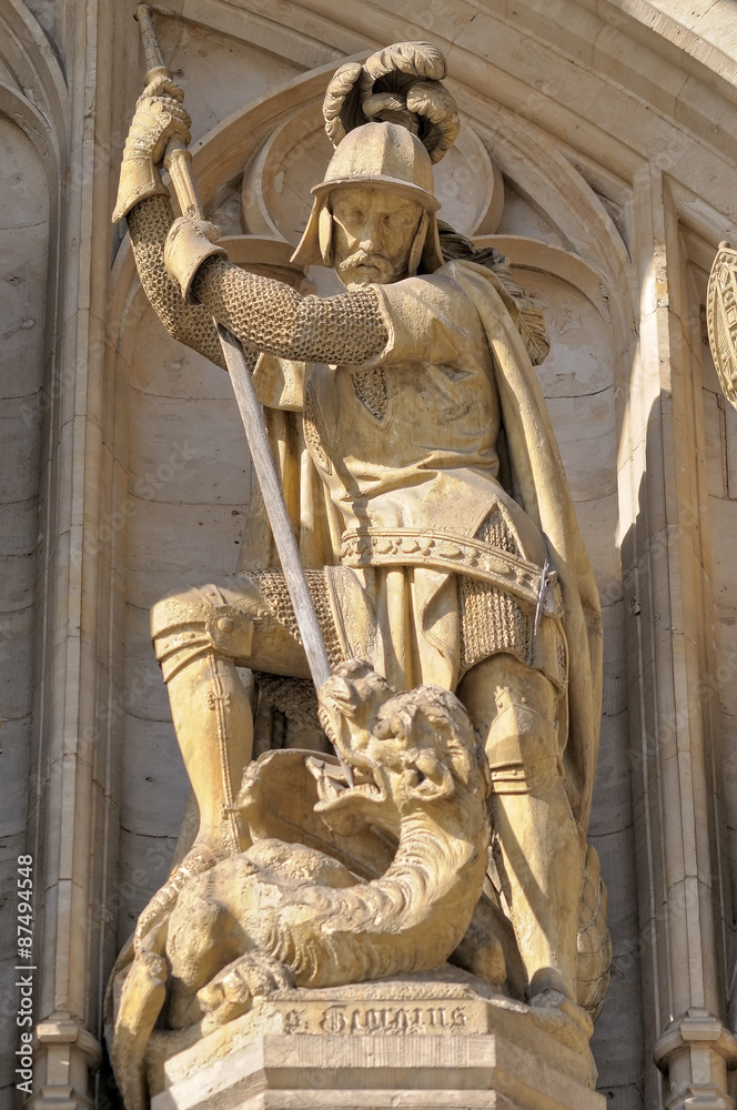 Medieval statue of Archangel Michael killing a devil on entry arch to ...