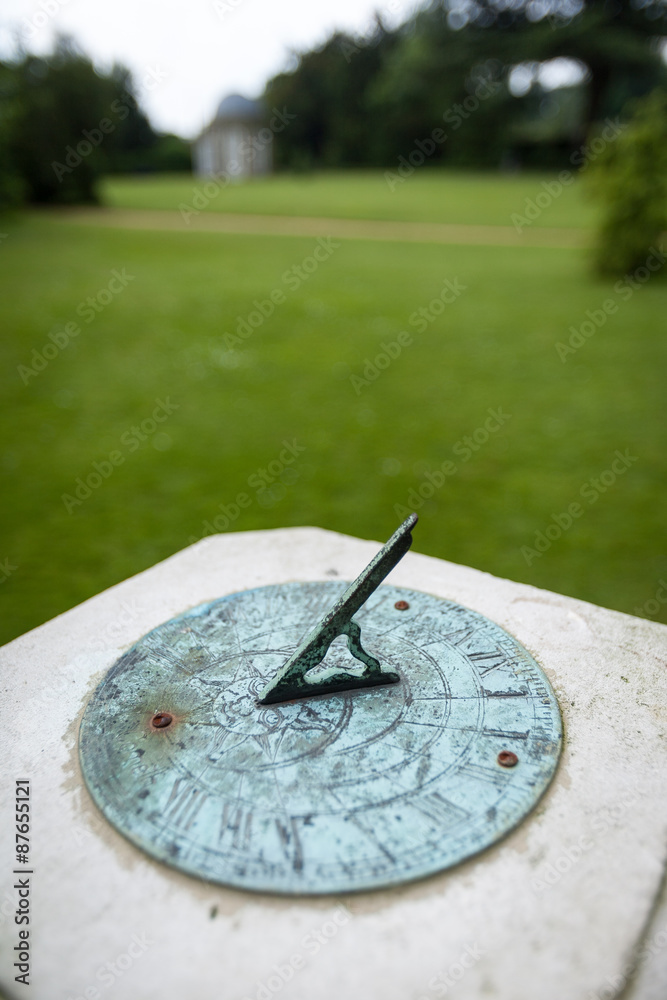 Copper Sundial. Shallow focus on a sundial in an English parkland ...