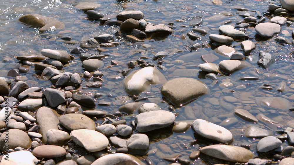 Sea pebbles in water. Ripples on the surface of water and solar Stock ...