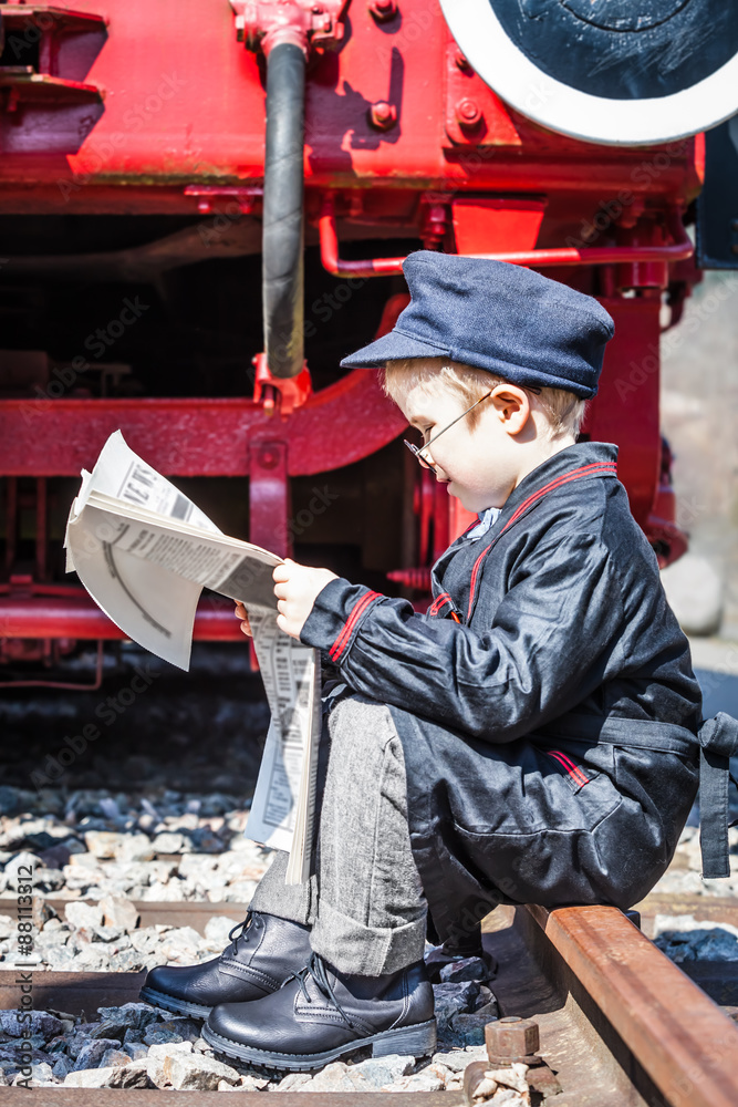 Newspaper Break / Small child boy as nostalgic locomotive driver ...
