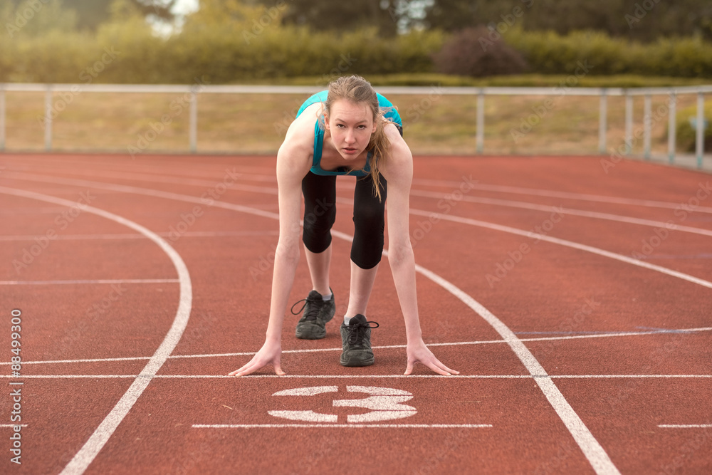 Young woman sprinter in the starter position Stock Photo | Adobe Stock