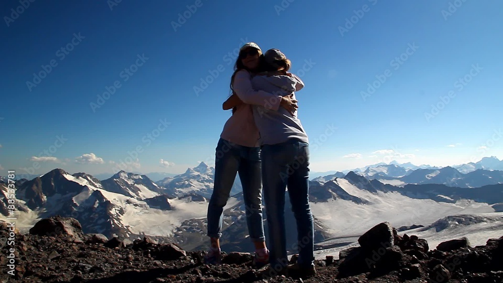 Vidéo Stock Two happy girls hugging in the top of the mountain with his ...