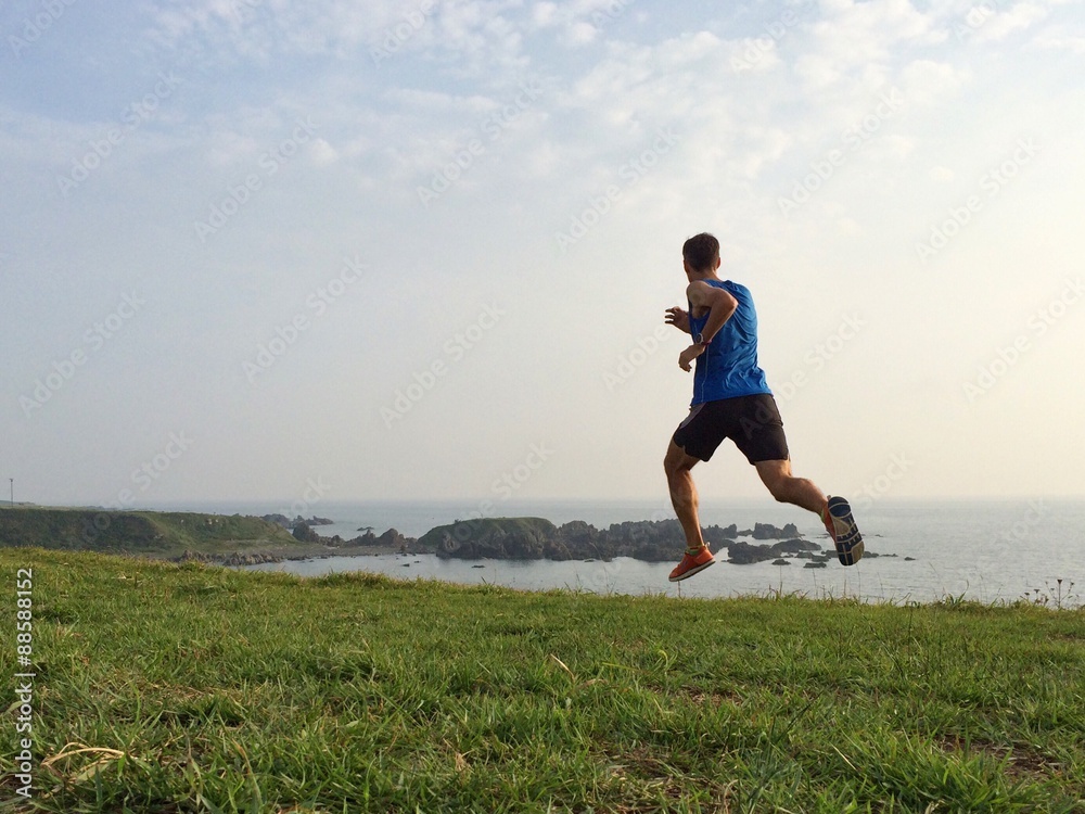 Runner on coastal cliff top path Stock Photo | Adobe Stock