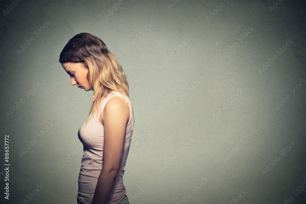 Sad lonely woman looking down isolated on gray wall background Stock ...