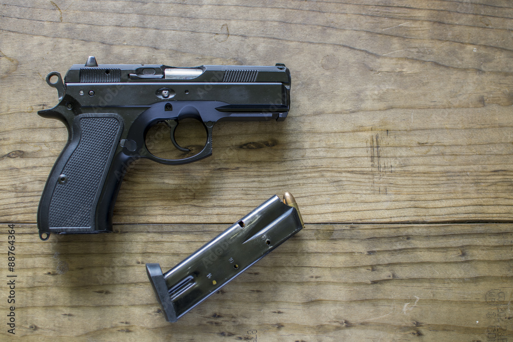 Metal 9mm Pistol with magazine on wooden table Stock Photo | Adobe Stock