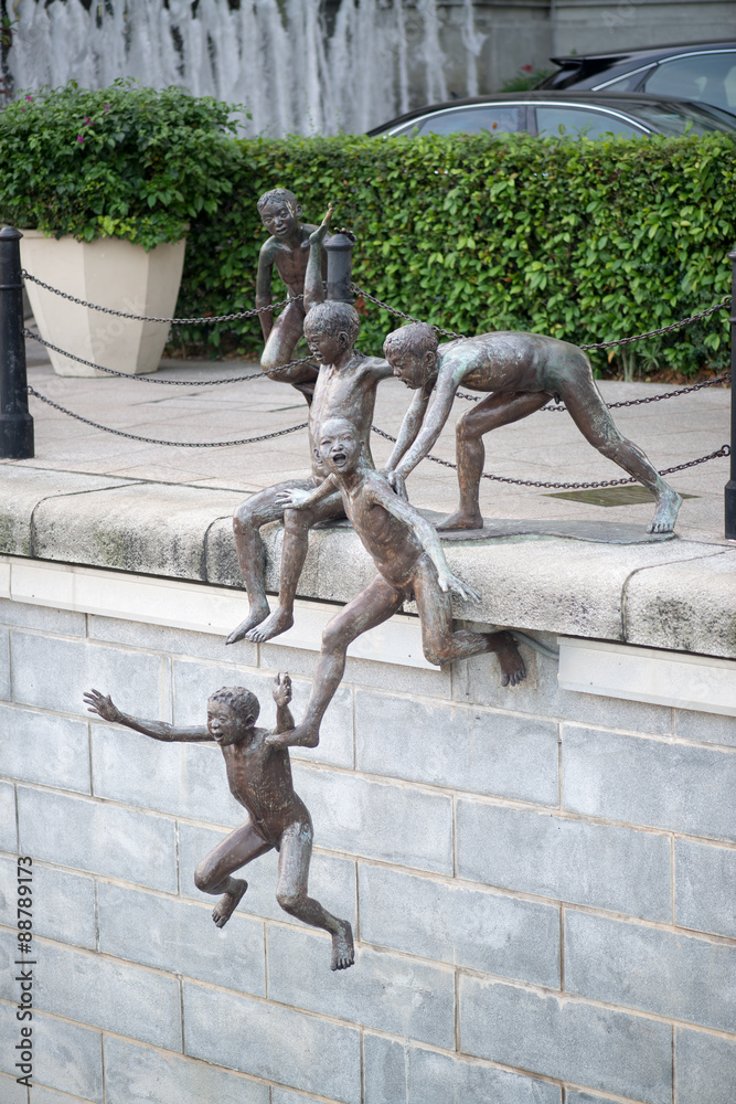 Raffles place, a statue of kids jumping to the river Stock Photo ...