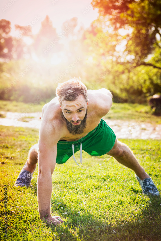 Sports man with brown hair and a beard on a natural background ...