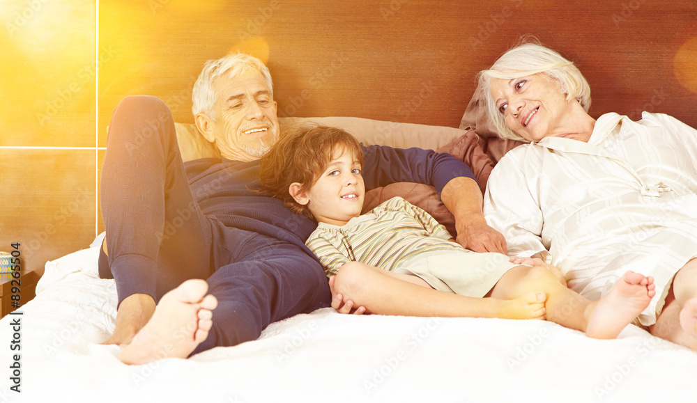 Großeltern mit Enkel auf Bett Stock Photo | Adobe Stock