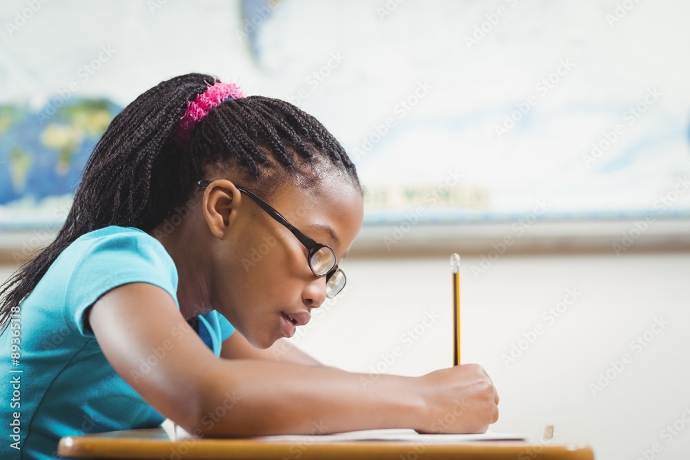 Focused african american pupil working at her desk in a classroom Stock ...