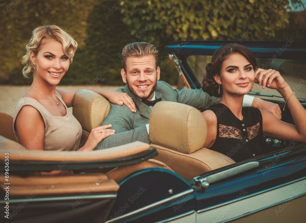 Wealthy friends in a classic convertible Stock Photo | Adobe Stock