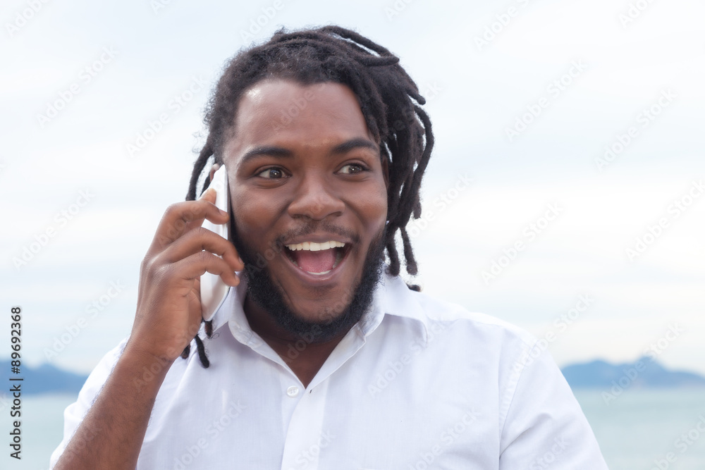 Lachende Mann mit Rastalocken im weissen Hemd am Telefon Stock-Foto ...