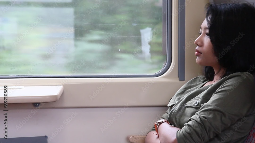 Woman sitting at the window of a moving train Stock Video | Adobe Stock