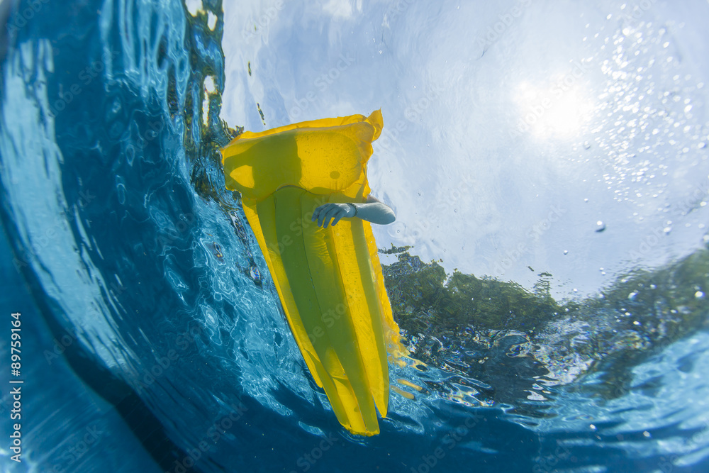 Girl relaxing on yellow water air matt li lo swimming pool underwater ...