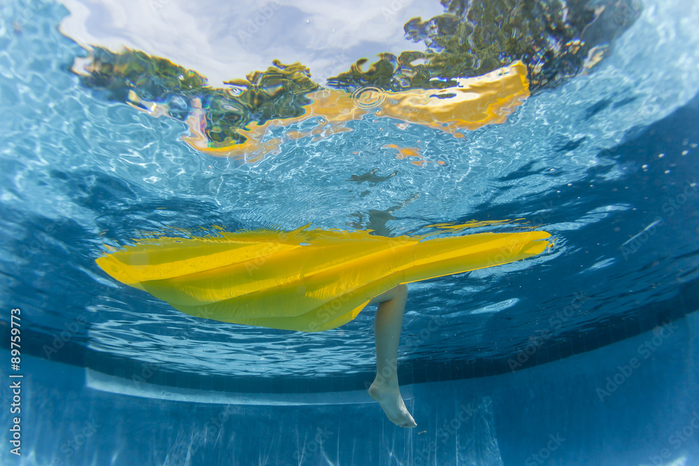 Girl relaxing on yellow water air matt li lo swimming pool underwater ...