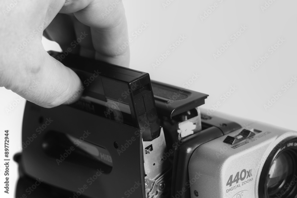 Video camera cassette loading. Man loading a cassette into a video ...