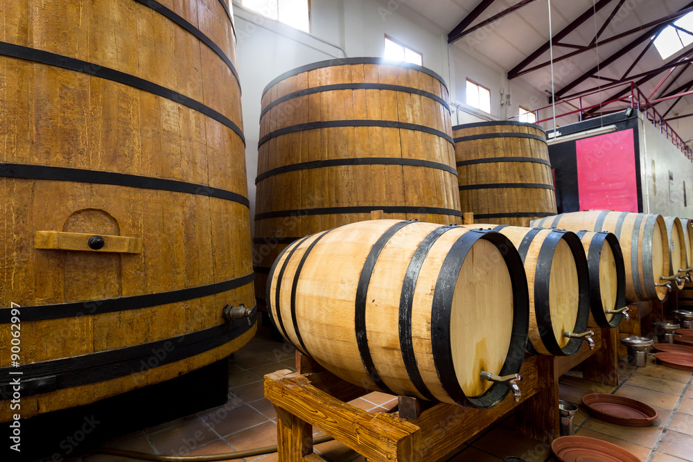 Big and small yellow barrels with iron rims and plastakovy bottles with ...