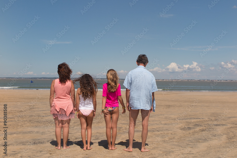 Back view of a family at the beach Stock Photo | Adobe Stock