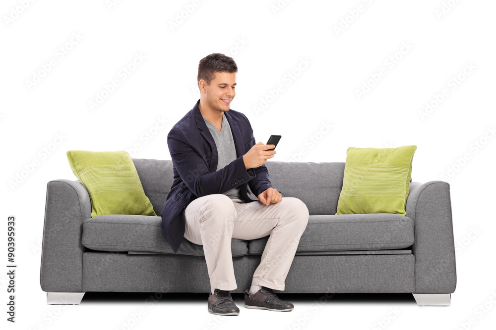 Man sitting on sofa and typing on his cell phone Stock Photo | Adobe Stock