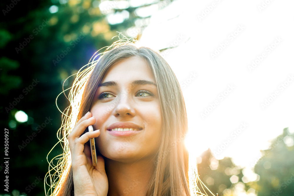 Beautiful, happy girl talking on the phone in the sun. Sunset. Stock ...