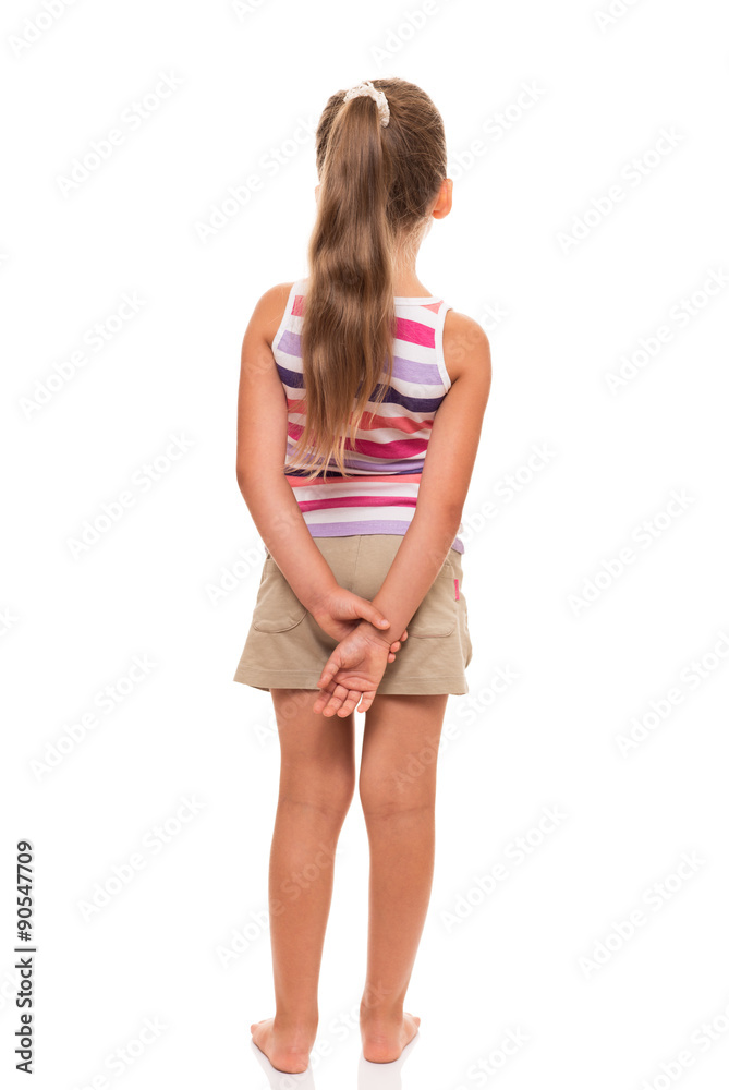 A little girl stands back, holding her hands behind her back Stock ... A little girl stands back, holding her hands behind her back Stock ...