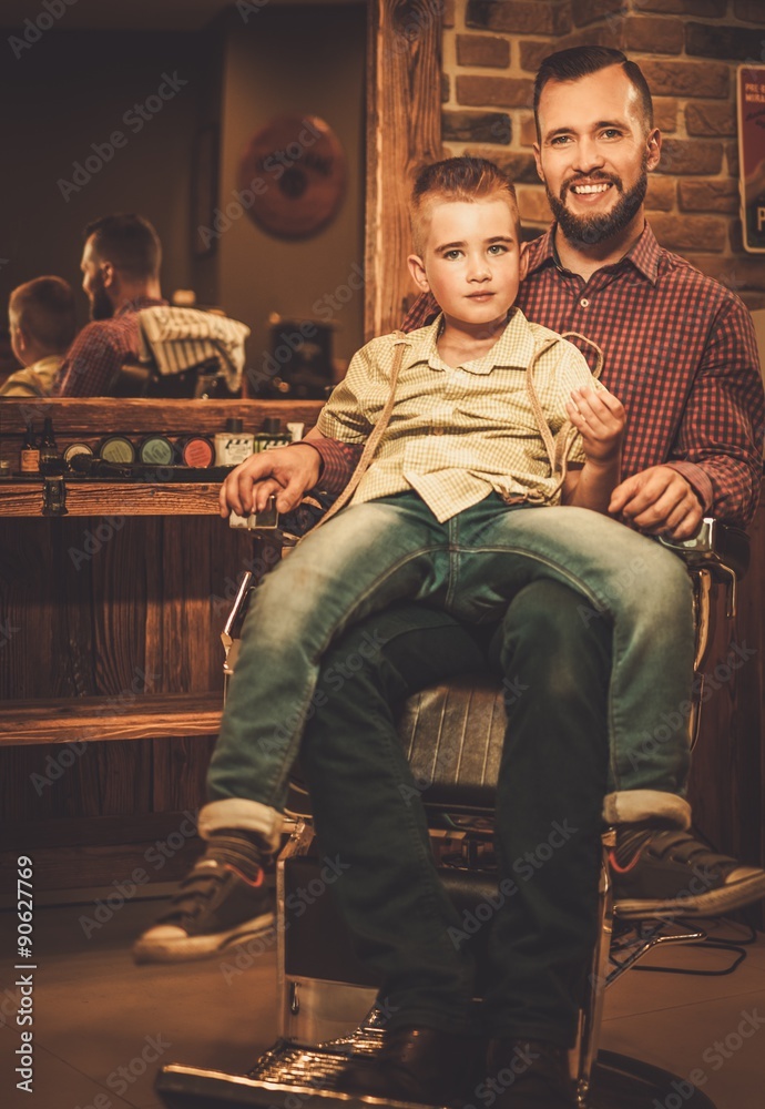 Stylish little boy and his father in a barber shop Stock Photo | Adobe ...