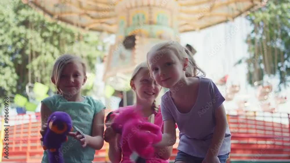 Three little girls at a fair showing their prizes to the camera Stock ...