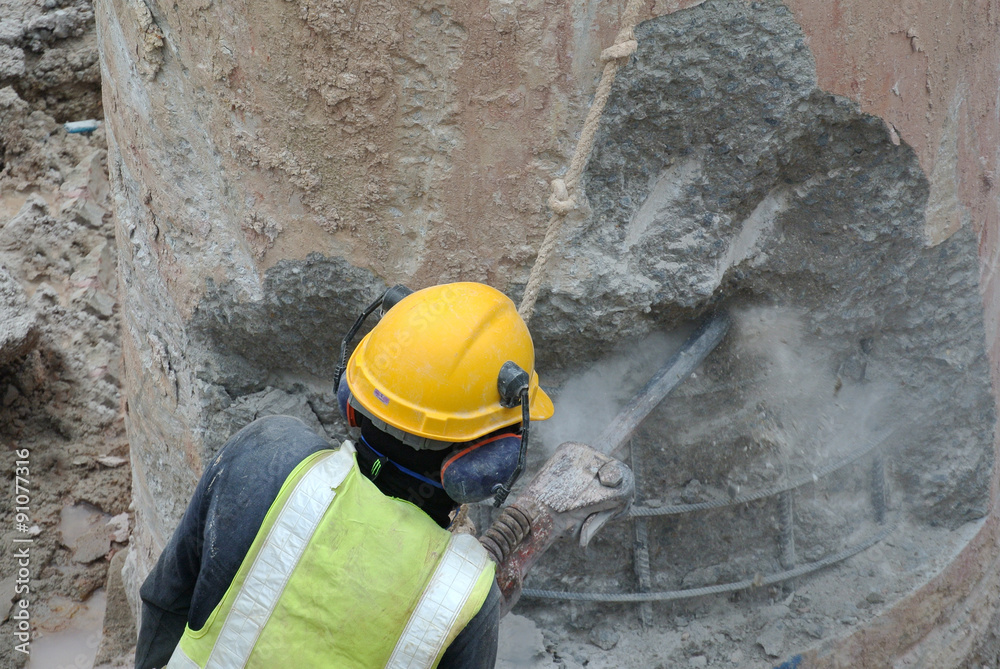 Construction workers using mobile concrete hacker at the construction ...
