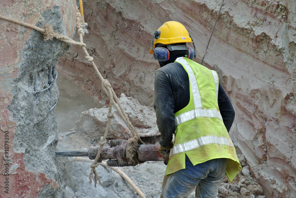 Construction workers using mobile concrete hacker at the construction ...