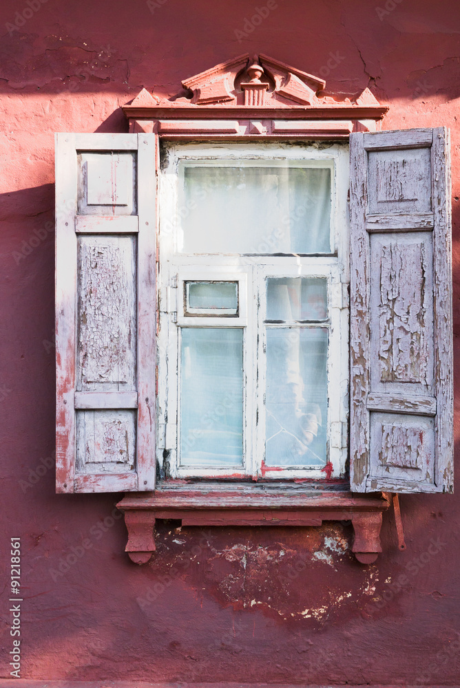 Old decrepit wooden window with exterior shutters and decor on the ...