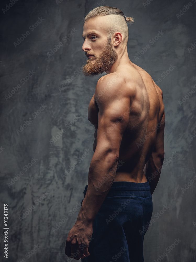 Muscular man with beard posing in studio. Stock Photo | Adobe Stock
