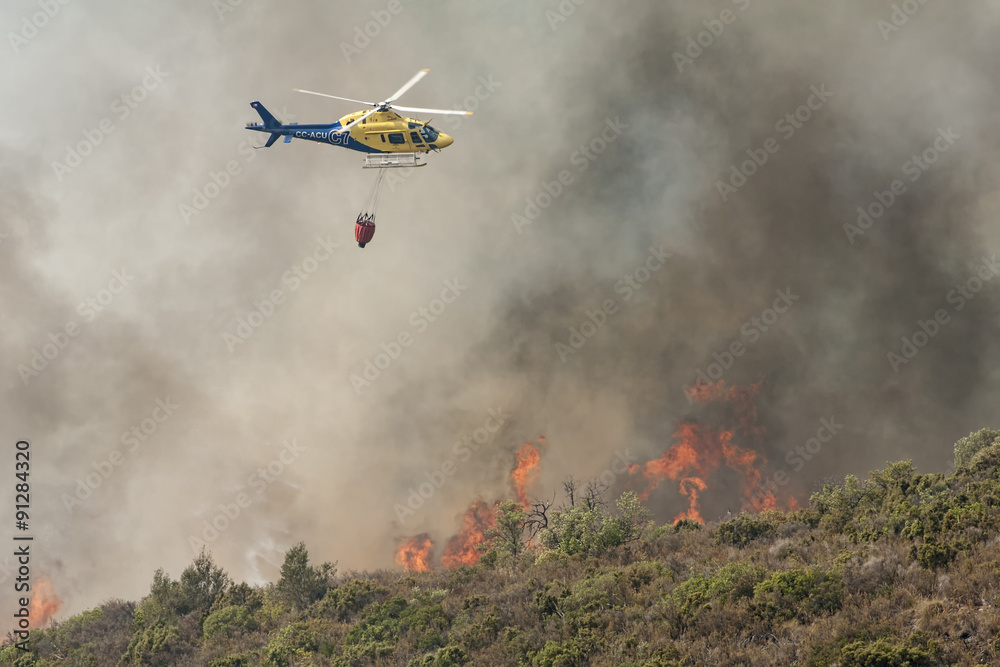 trágico incendio forestal con helicóptero apagando el fuego Stock Photo ...