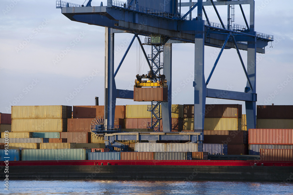 Gantry crane lifting a container from stack to a barge Stock Photo ...