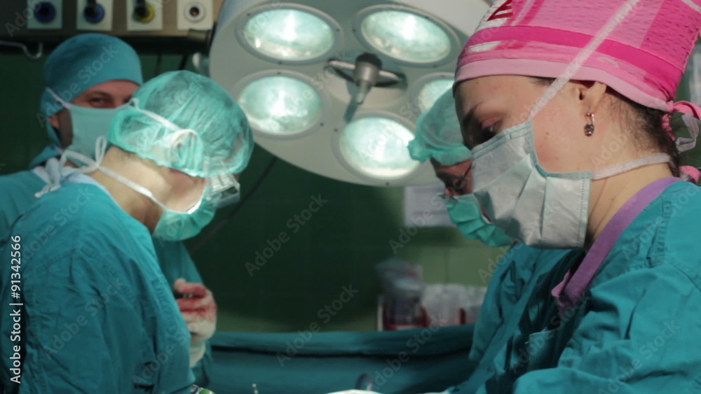 Nurse preparing hip implant during surgical operation in operating room ...