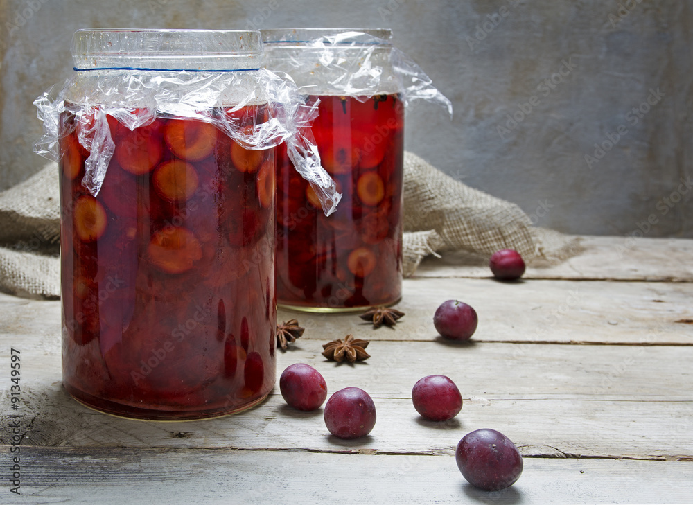 pickled plums with spices in two glasses on a rustic wooden tabl Stock ...