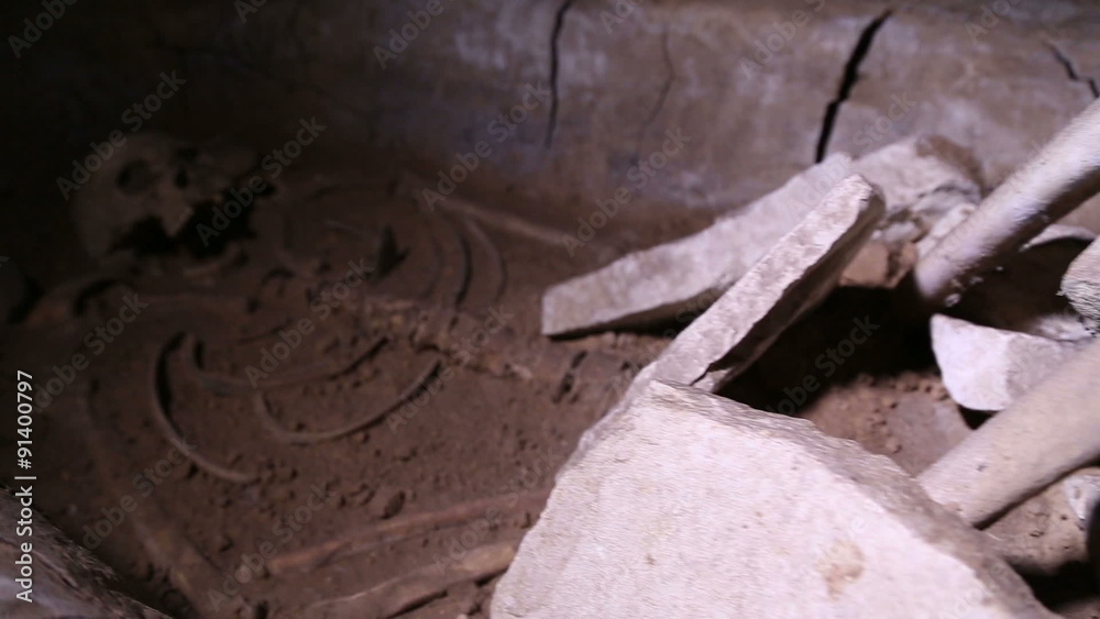 Human skeleton, skull, bones, excavated a burial, in the grave are clay ...