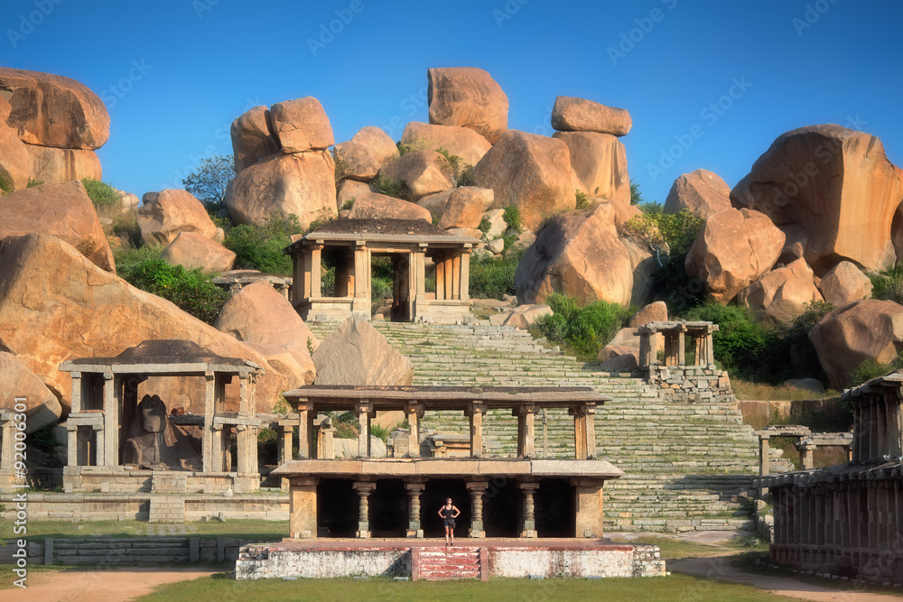 Ancient temples surrounded by gigantic stones in Hampi, India. A young ...