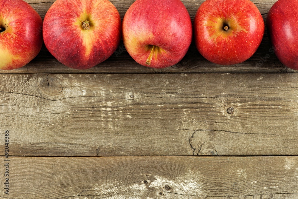 Freshly harvested apples, top border on rustic aged wood background ...