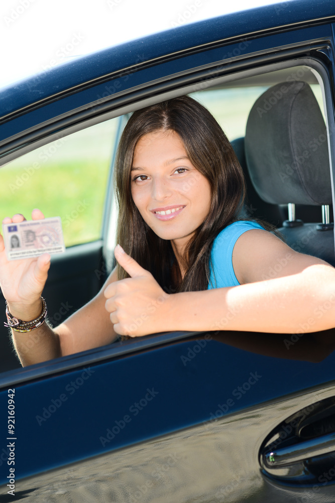 cheerful and happy young woman in her car showing her new driving ...