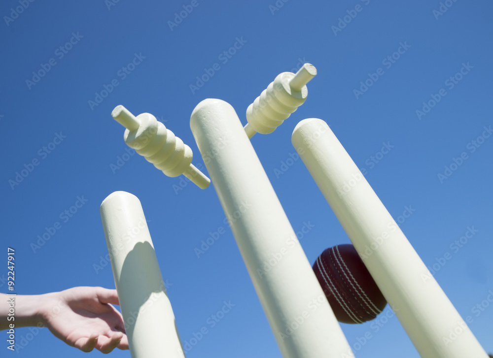 Bails fly in air after ball hits cricket stumps Stock Photo | Adobe Stock