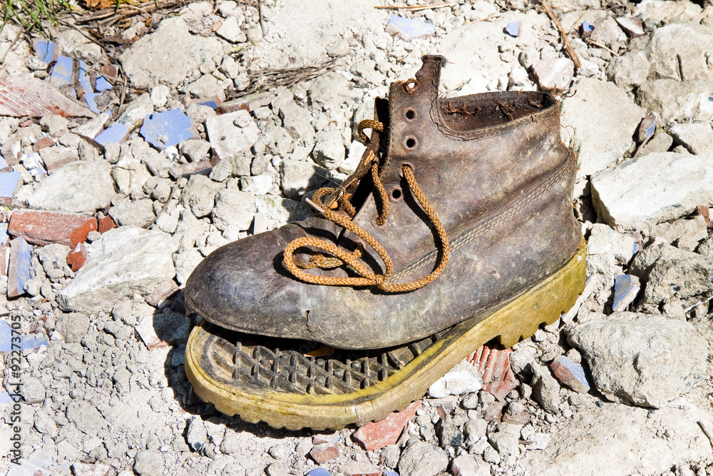 Old broken boot abandoned in a rubble background Stock-Foto | Adobe Stock