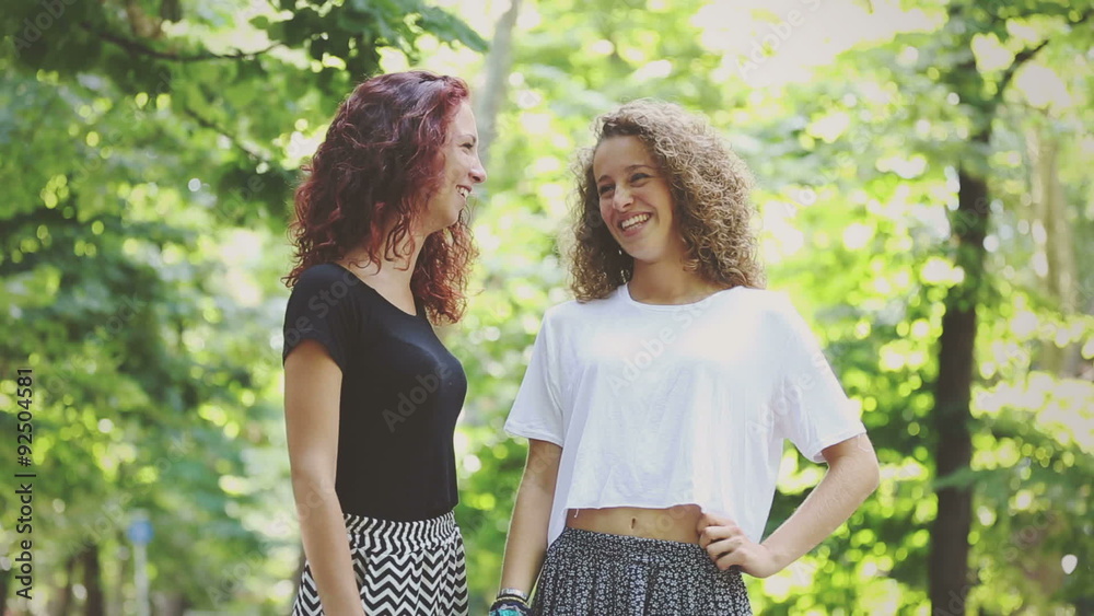Two beautiful girls talking and laughing at park Stock Video | Adobe Stock