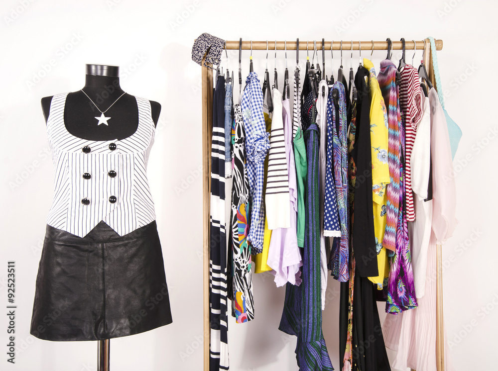 Dressing closet with colorful clothes arranged on hangers and an outfit ...