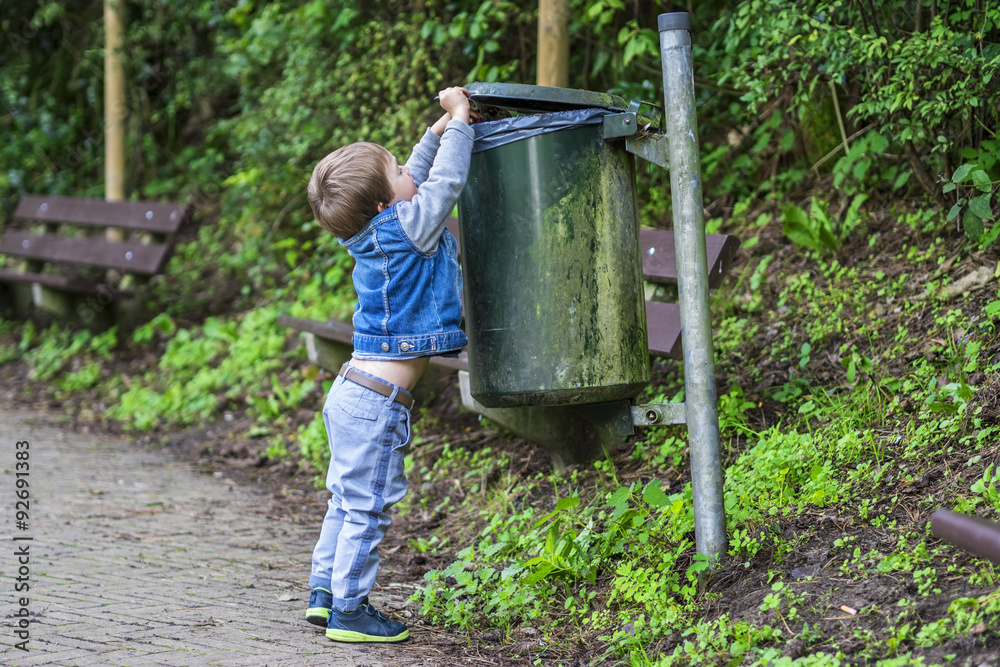 Little boy throwing trash in the bin Stock Photo | Adobe Stock