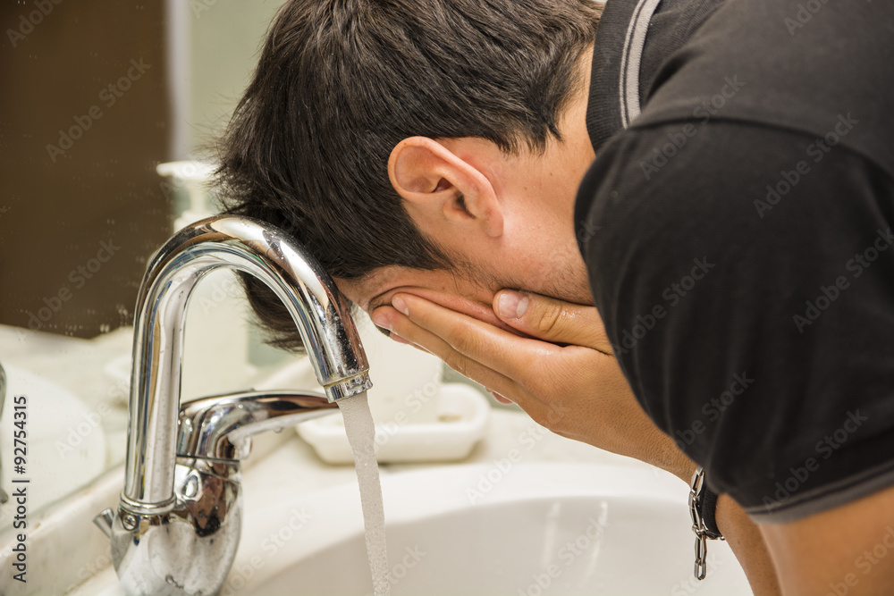 Attractive young man washing his face Stock Photo | Adobe Stock